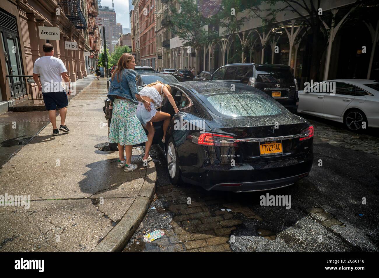 Shoppers enter a Tesla livery in Soho in New York on Saturday, June 26 ...