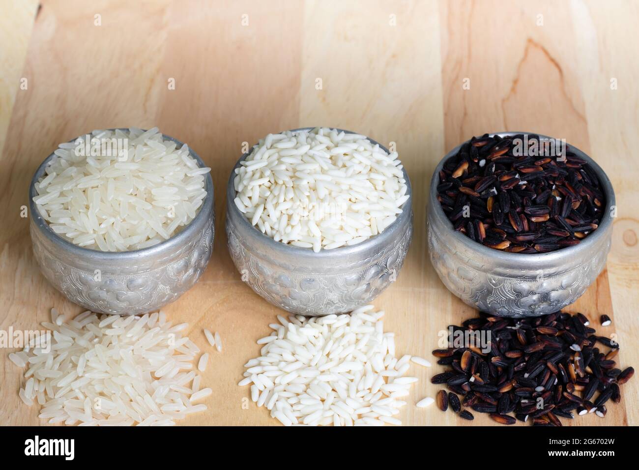 Three types of Thai rice in a silver container. On wood background and ...