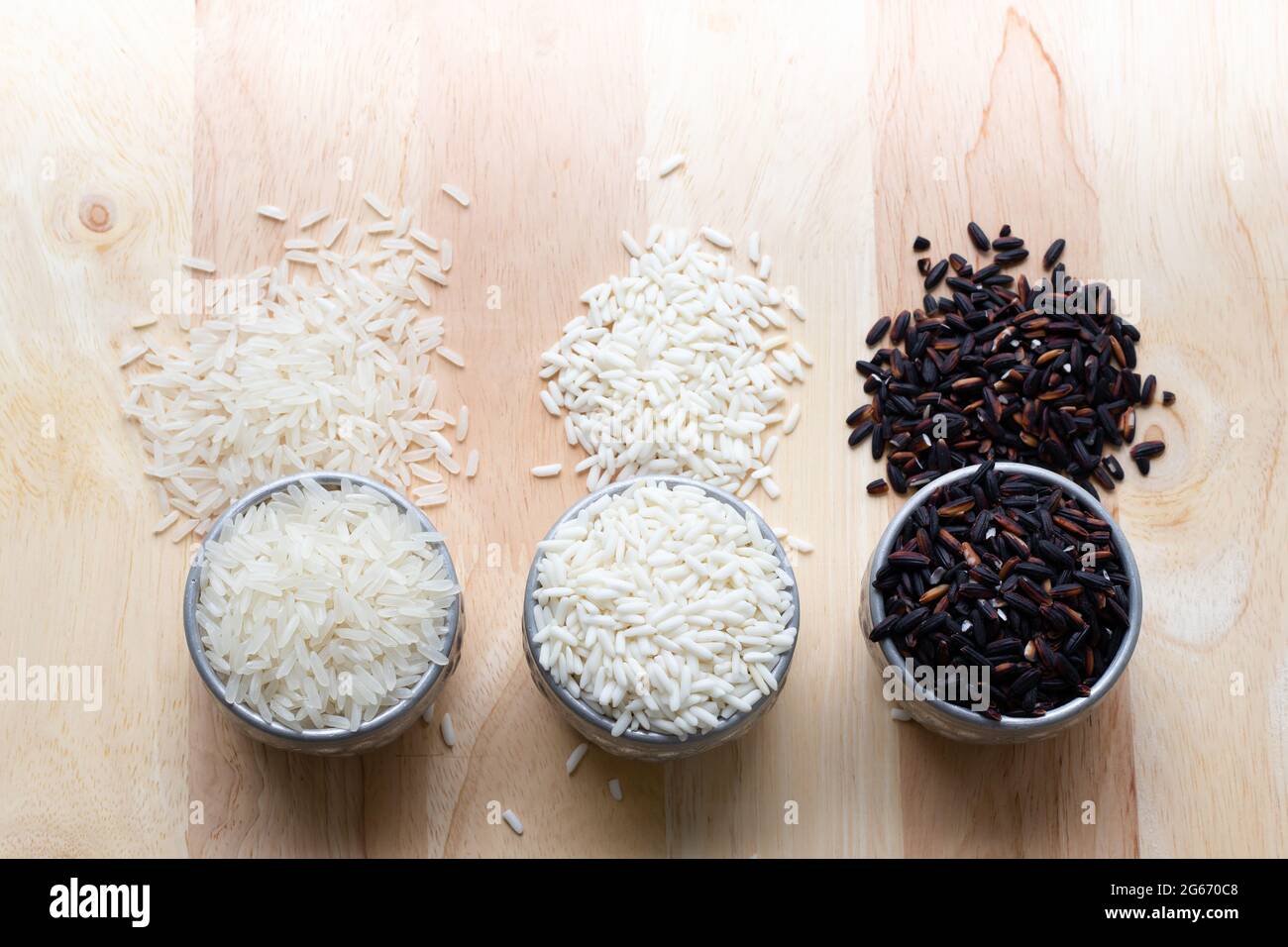 Three types of Thai rice in a silver container. On wood background and ...