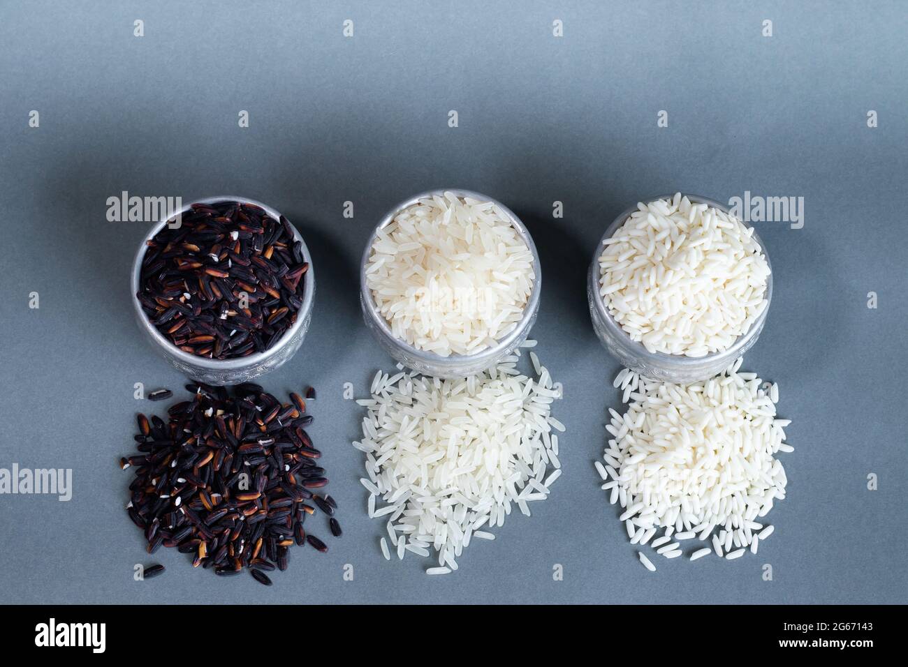 Three types of rice in a silver container. On a gray background and ...