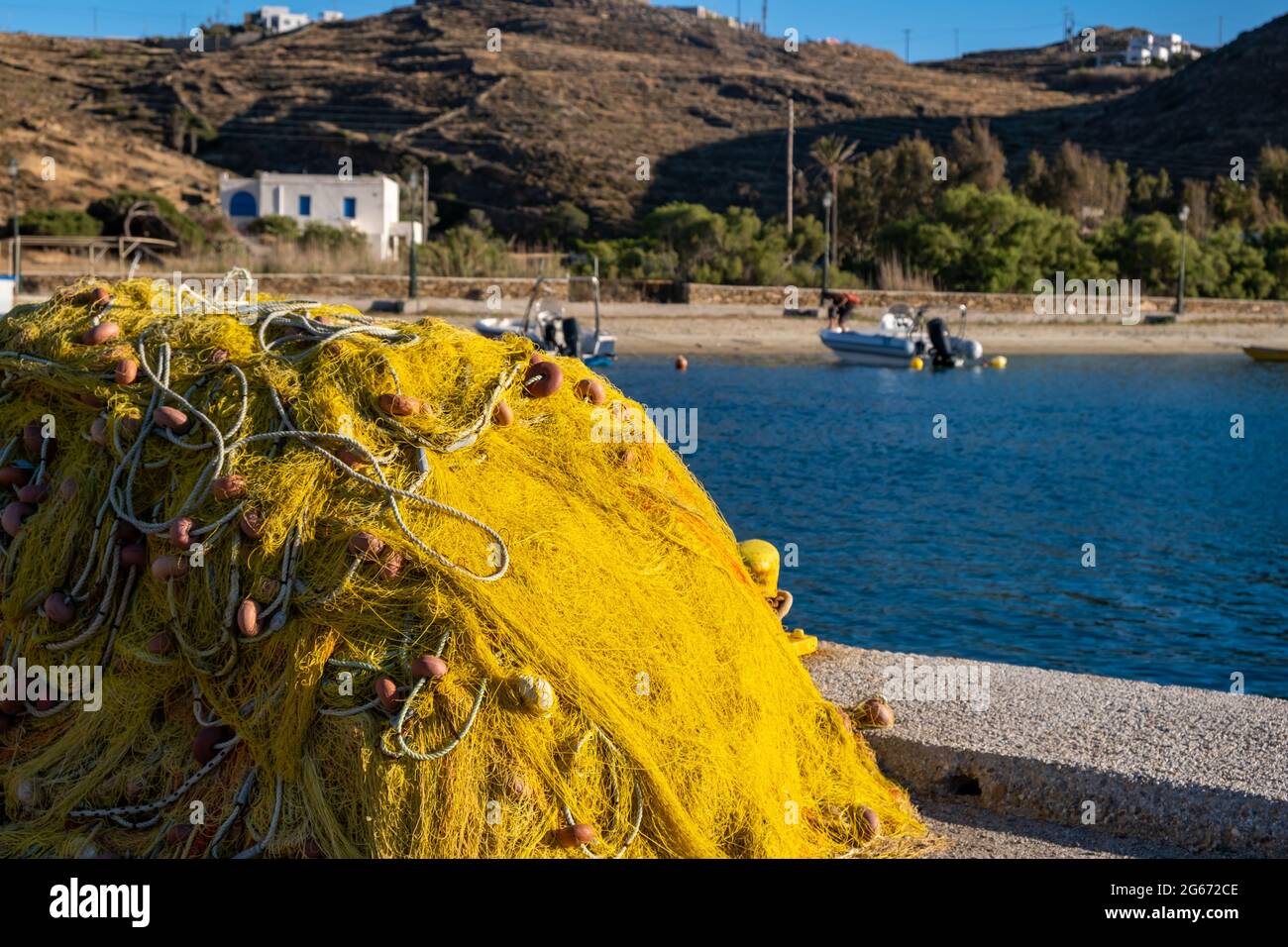 Fishing nets stack on the fisher port dock drying under the sun. Yellow ...