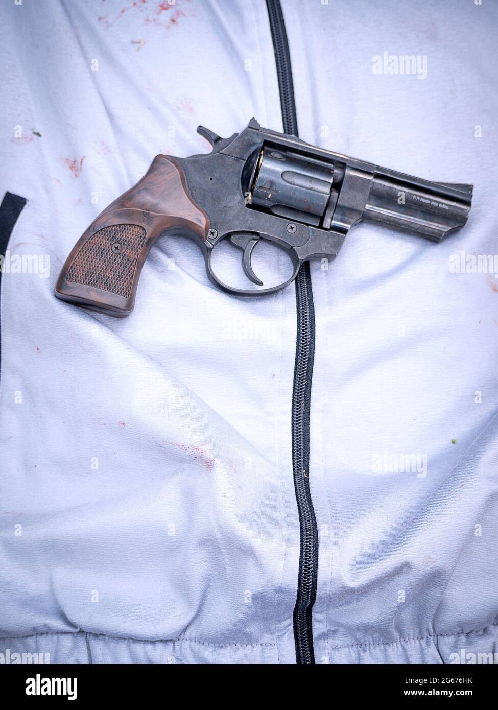 Vertical view of 9mm revolver laying on male's white tracksuit Stock ...