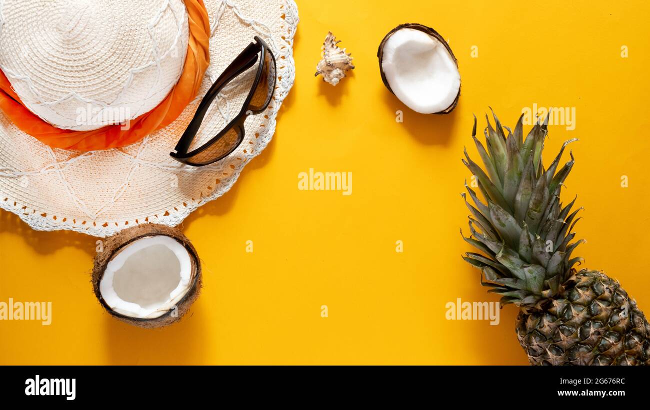 Summer composition. Coconut, hat and sunglasses on a yellow background ...