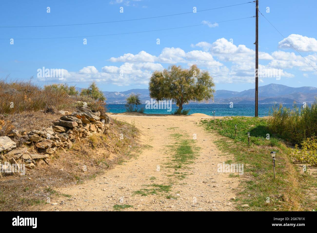 Pathway to the sandy Logaras beach with blue sea water on Paros island ...