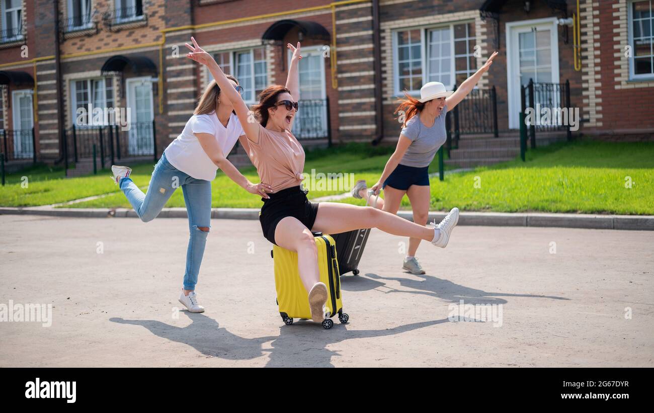 Three joyful Caucasian friends are having fun and chasing each other ...