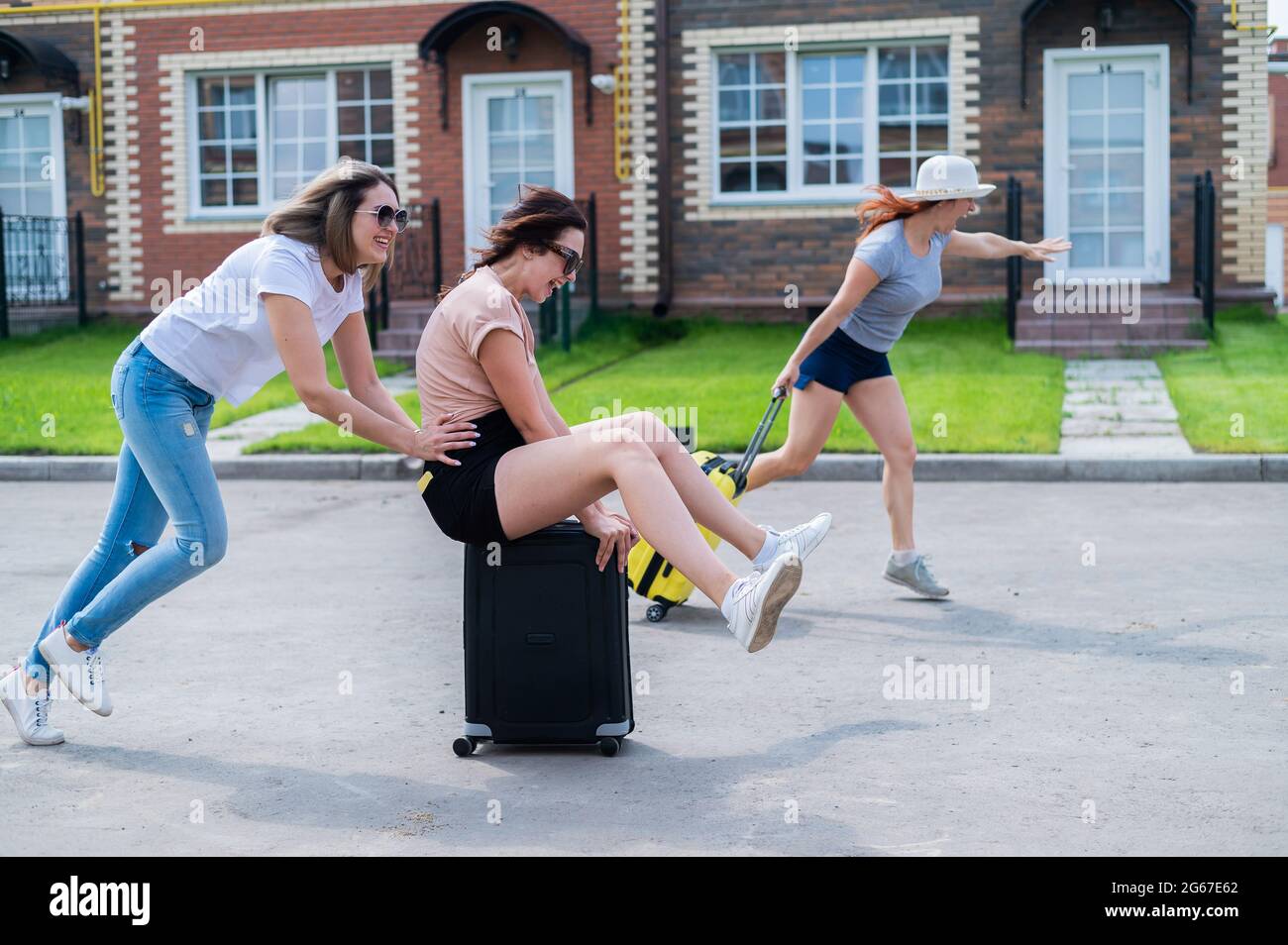 Three joyful Caucasian friends are having fun and chasing each other ...