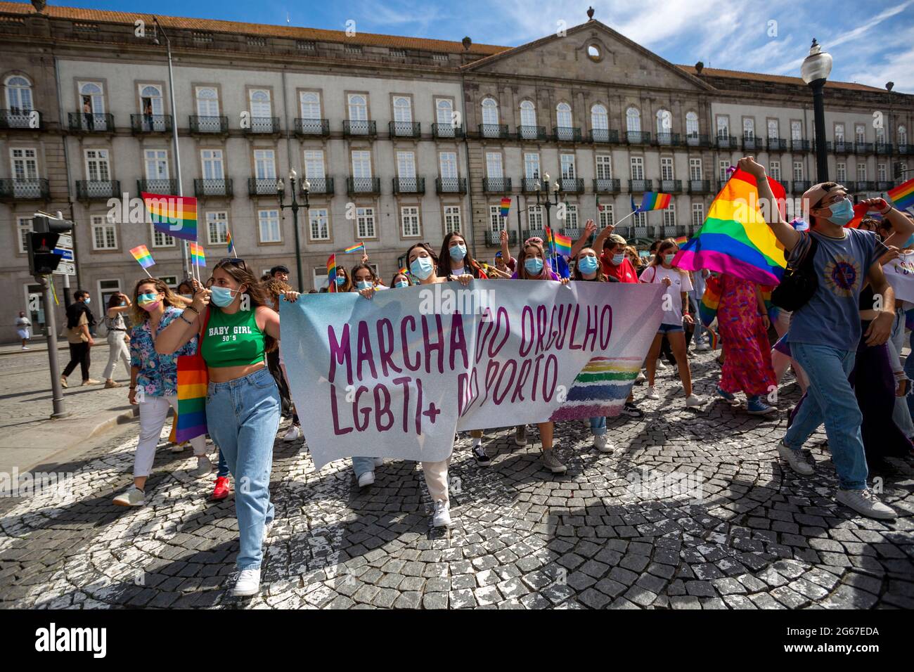 Participants hold banners and LGBT flags during the parade. A group of ...