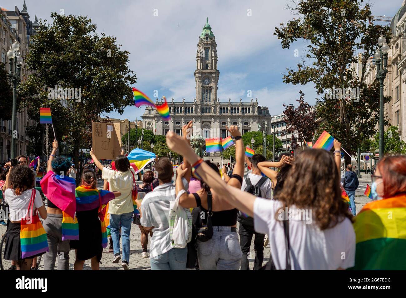 Participants hold banners and LGBT flags during the parade. A group of ...