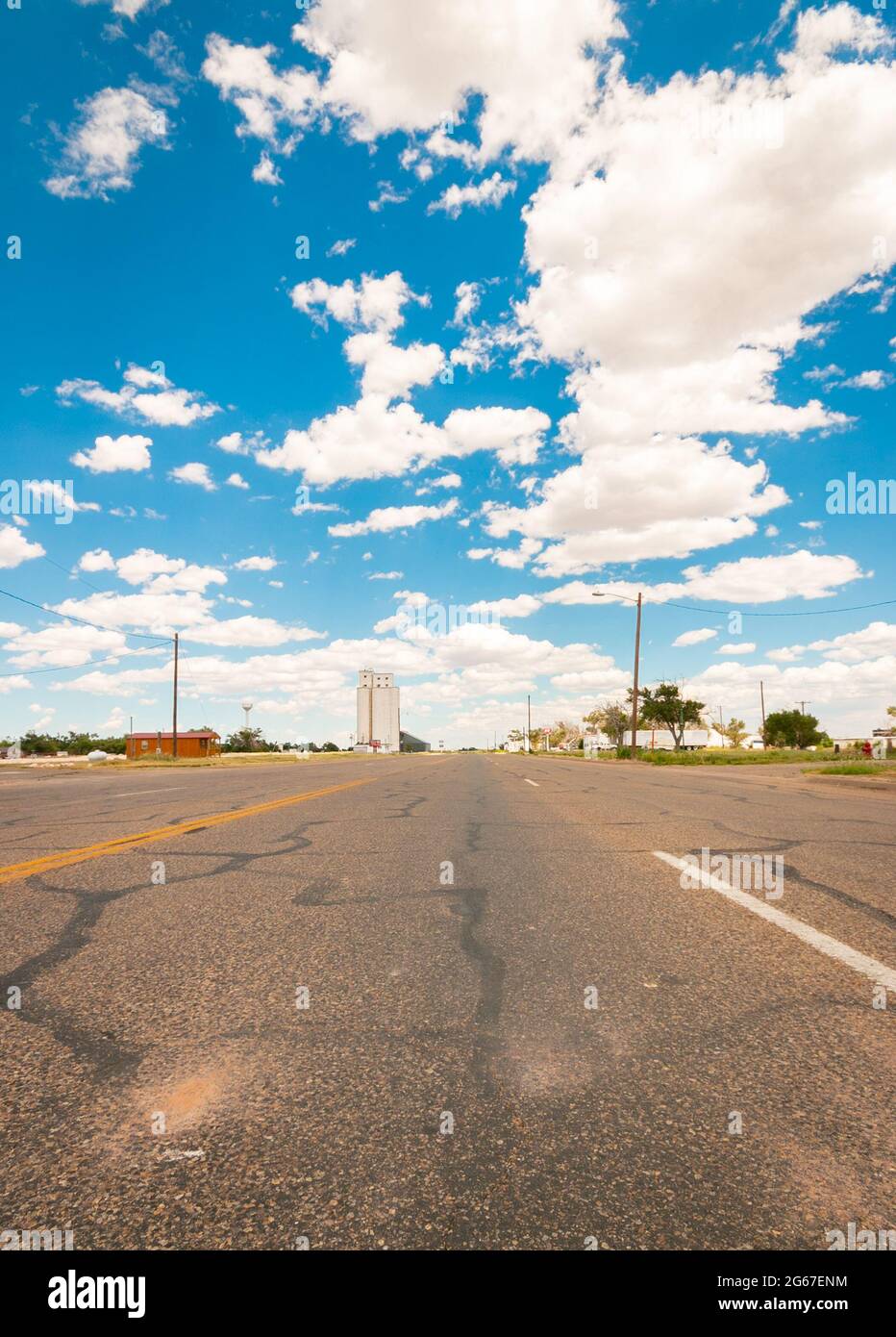 wide angle shot of empty road with grain silo in distance on Route 66 ...