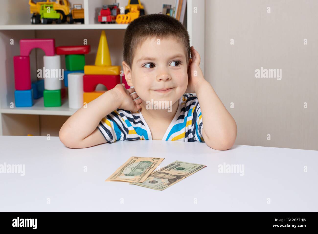 A beautiful child and dollar bills. The boy is thinking about where to ...