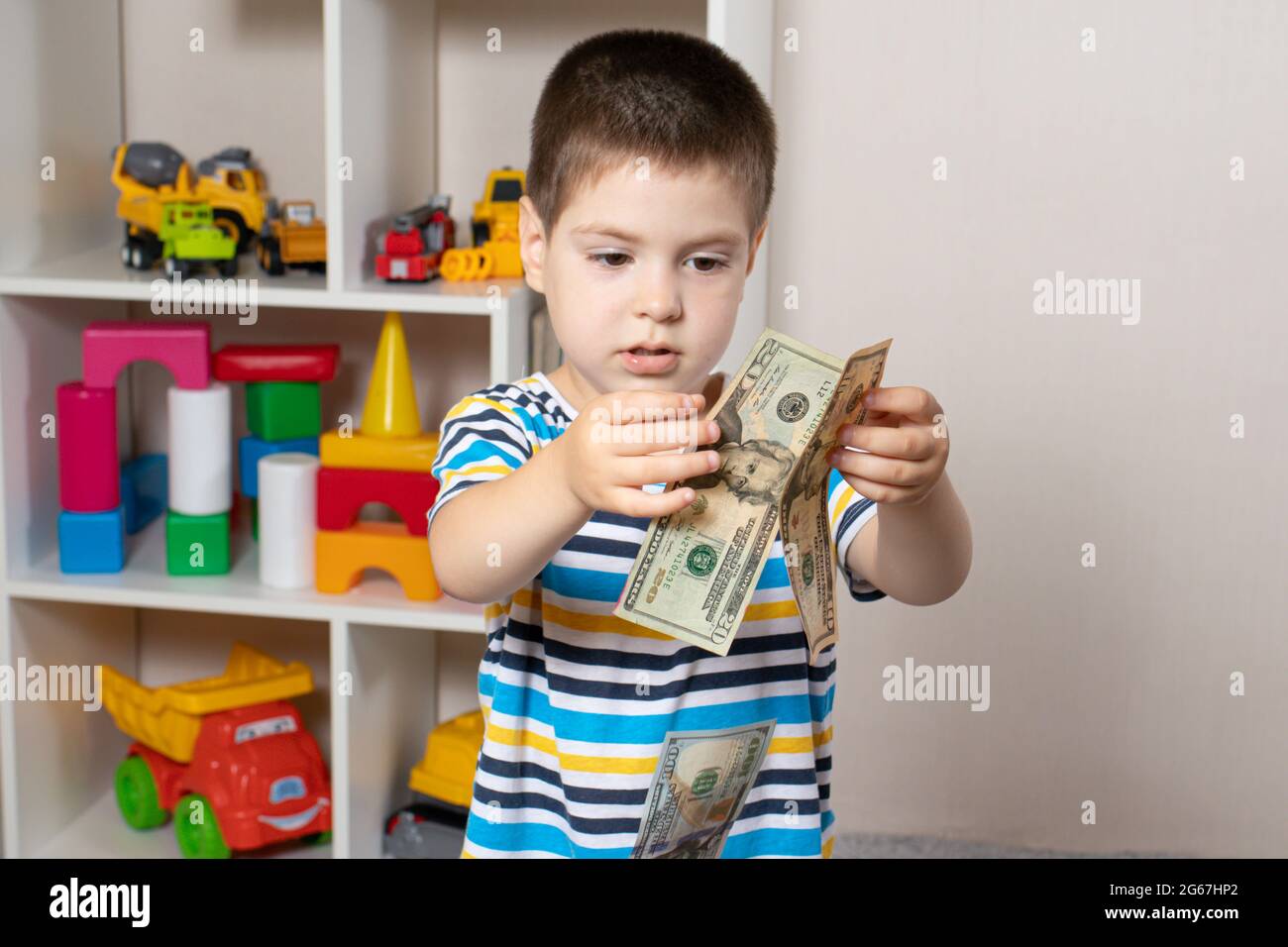 A little baby boy drops dollar bills. Children's handling of money ...