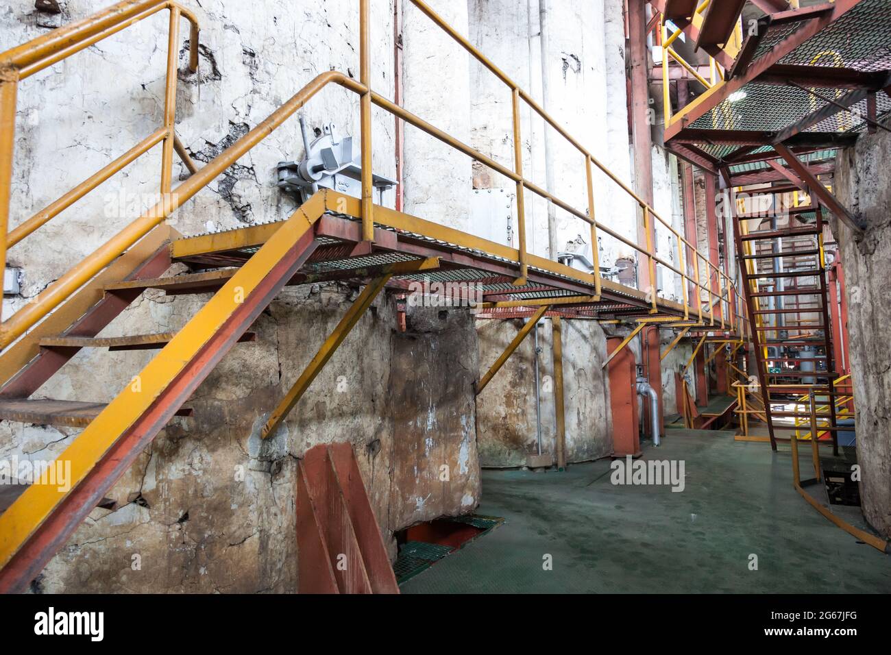 Internal walkway alongside heavy machinery inside a sugar refinery ...