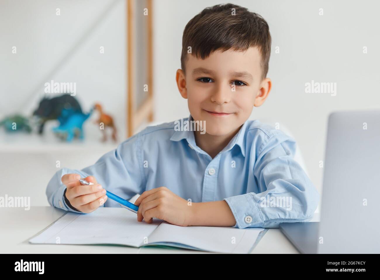 Clever kid doing homework using laptop and internet. Elementary school ...