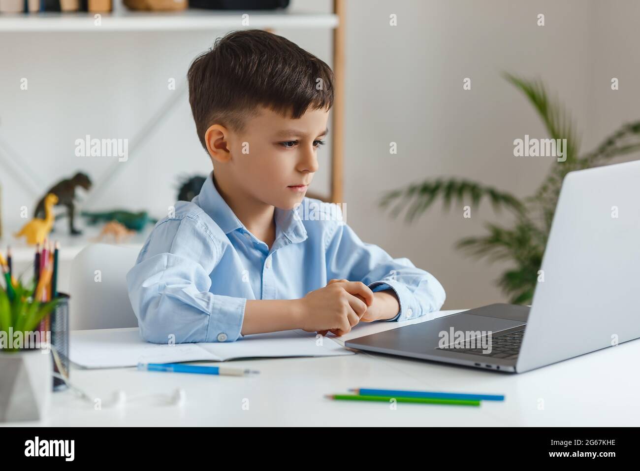 Clever kid tired to learn difficult homework using laptop and internet ...