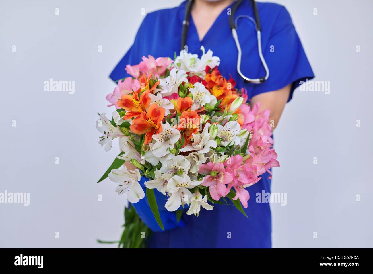 Health day, close-up bouquet of flowers in the hands of doctor nurse ...