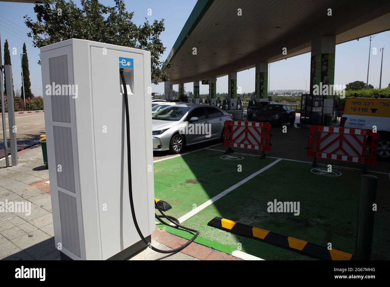 An electric car charging post with designated green parking spaces for ...