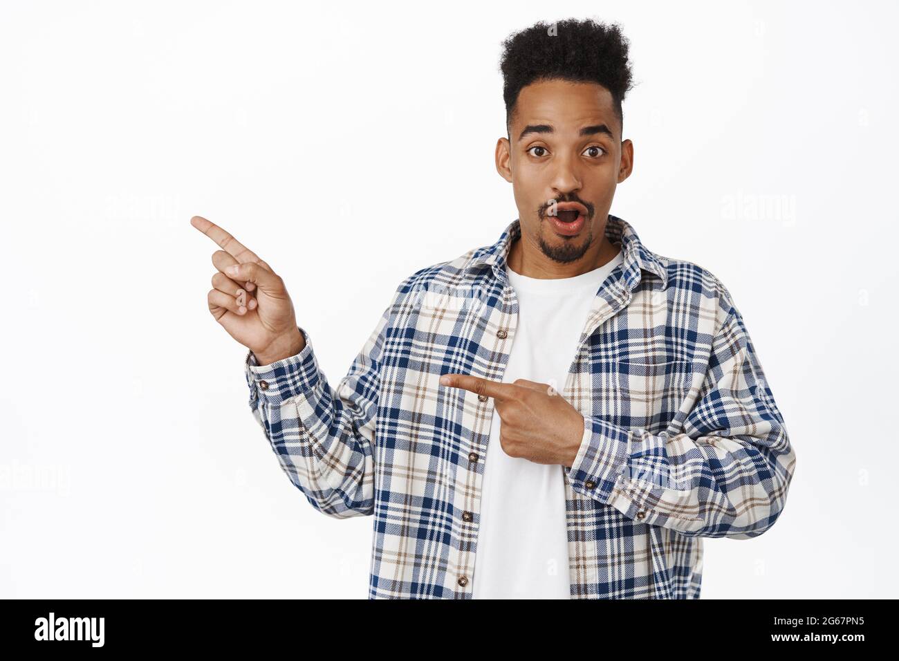 Excited and amazed african american guy, pointing fingers left at sale ...