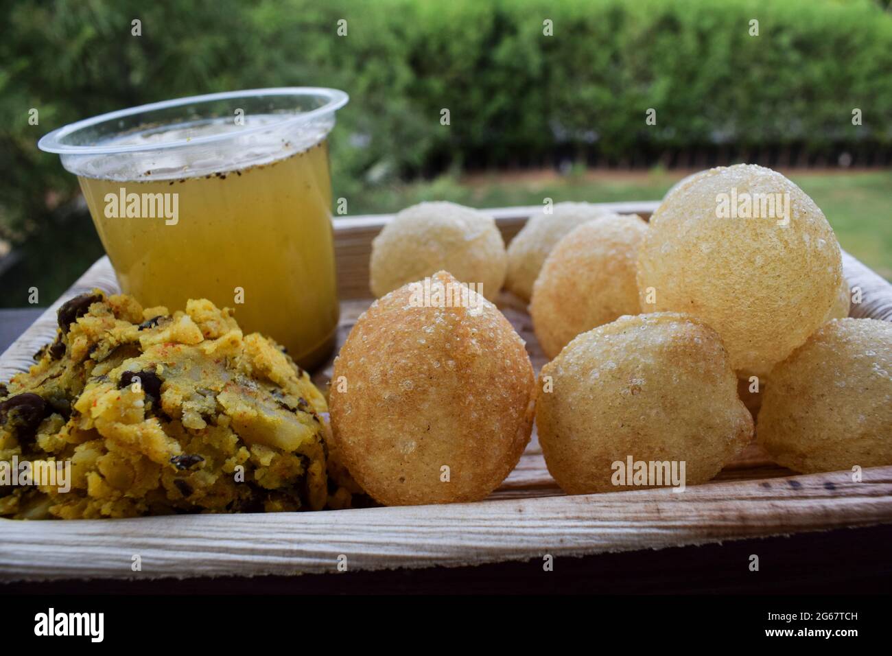 Tasty Indian snacks Pani puri with chat masala water and sliced onions ...