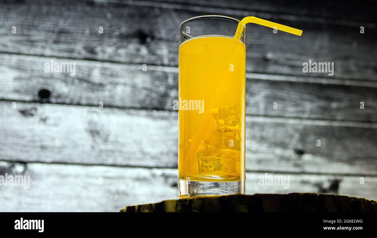 Yellow lemonade in a glass transparent on a background of wooden boards ...