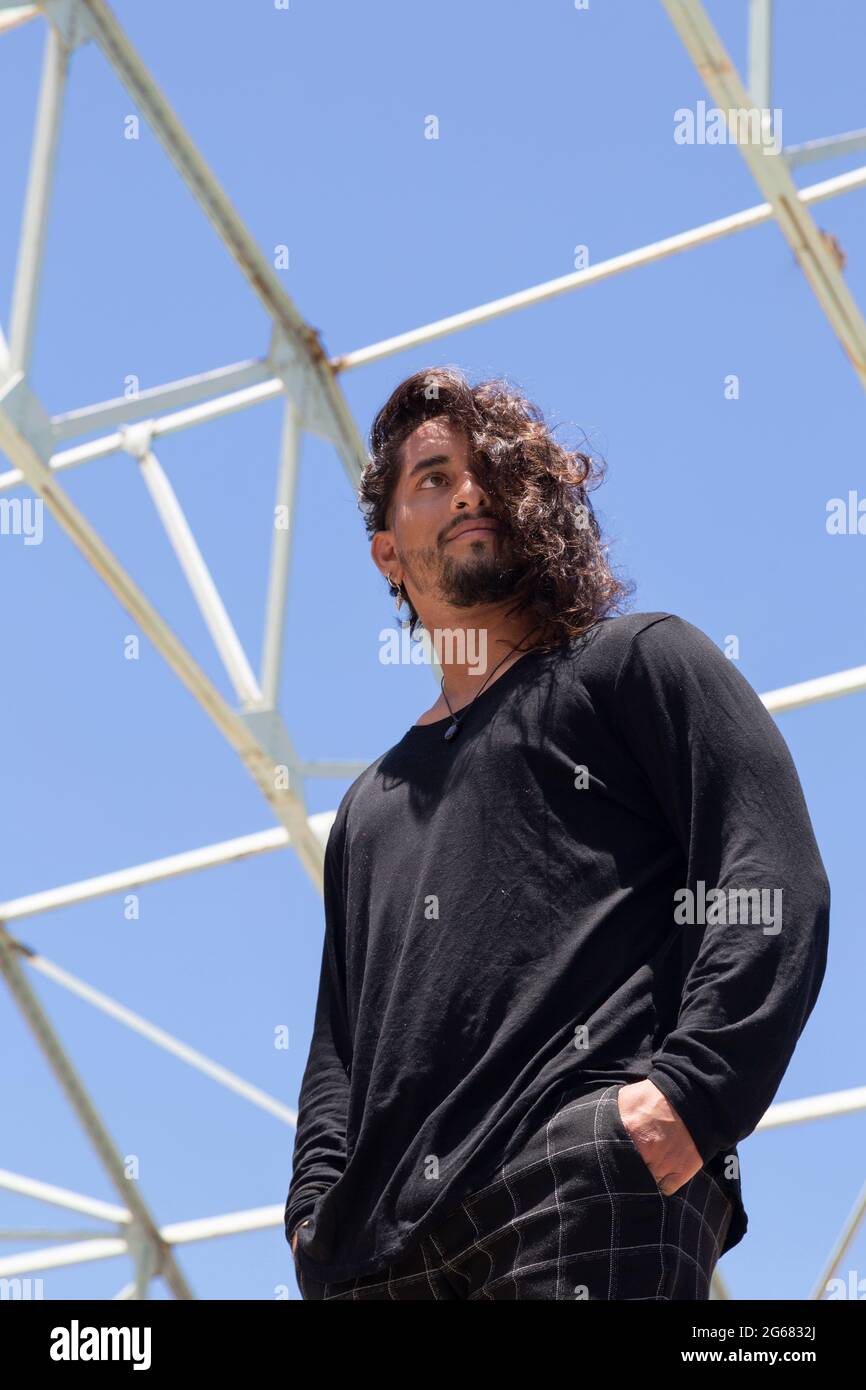 Young hispanic latin street dancer with blue sky background and metal ...