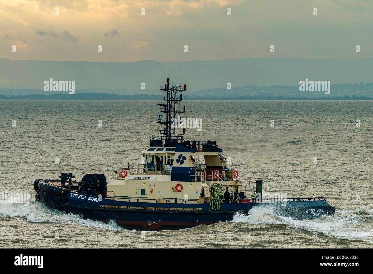Tugs heading out to sea Stock Photo - Alamy