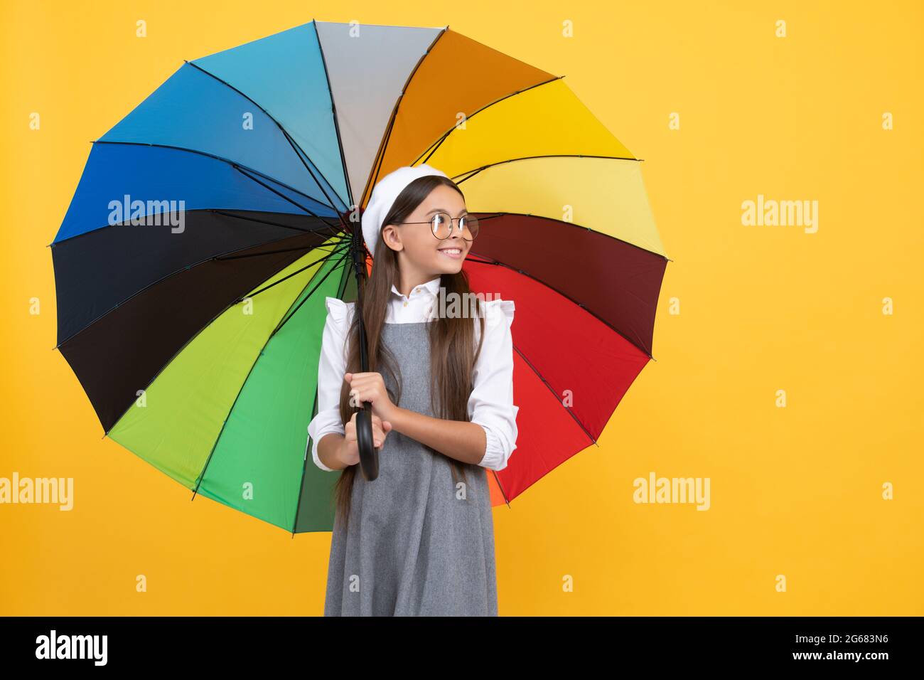 cheerful teen child under colorful parasol. kid in beret with rainbow ...