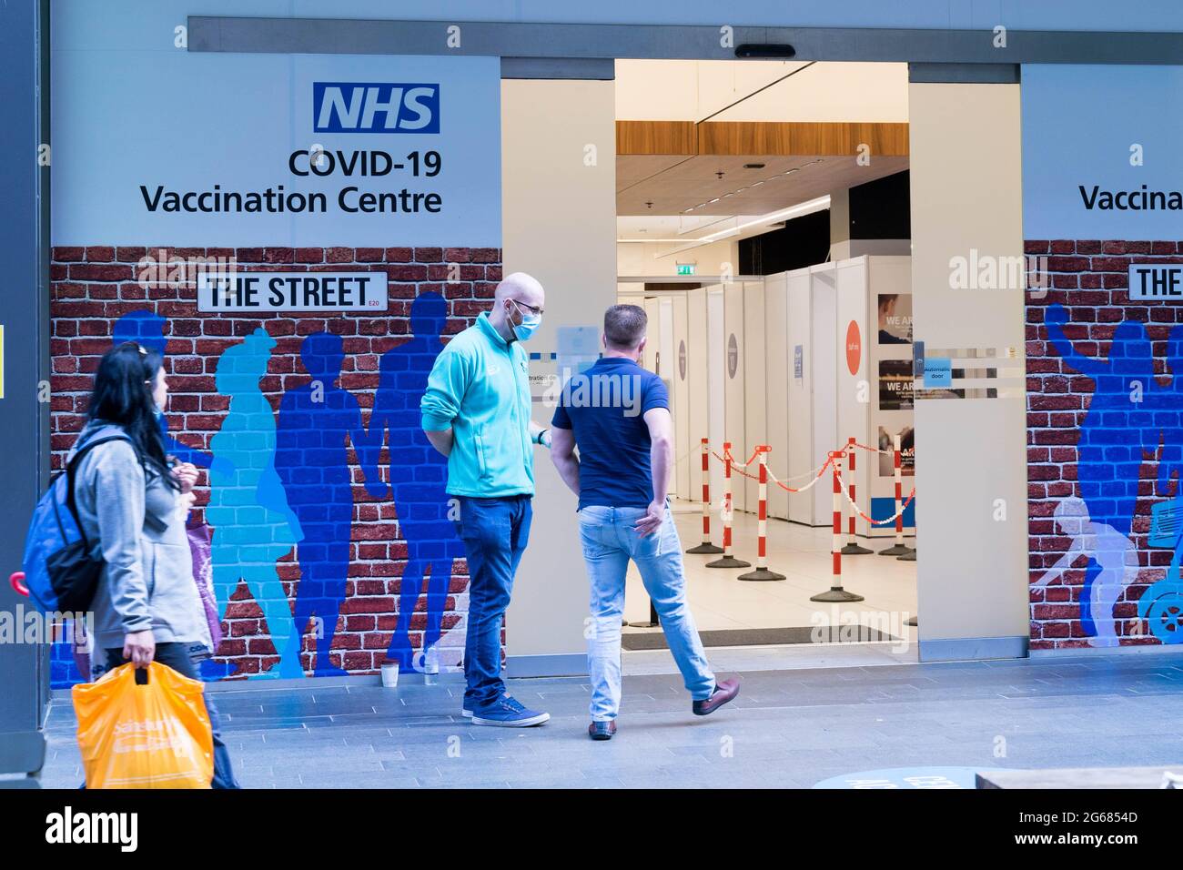 People queue outside NHS COVID-19 vaccination centre in Stratford ...