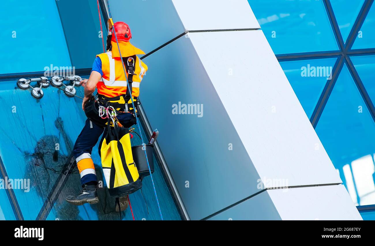 window cleaner working on a glass facade modern skyscraper Stock Photo ...