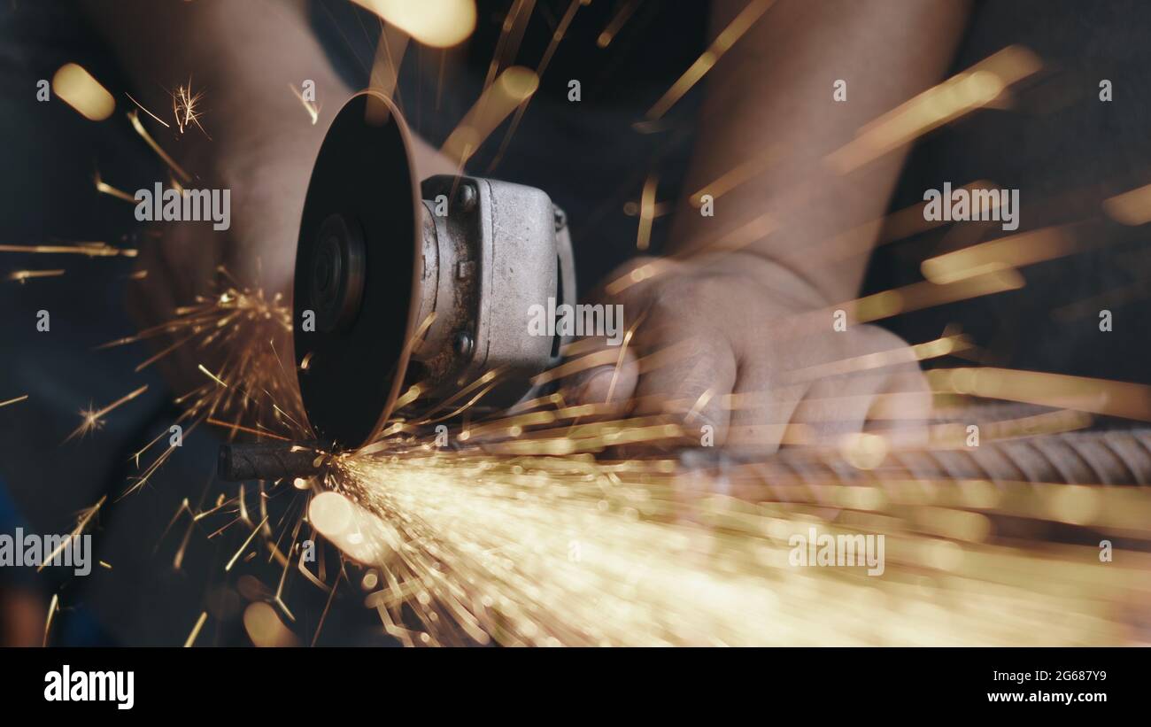 Worker man using electric wheel grinding and cutting on steel structure ...