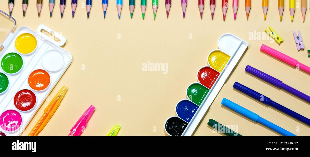 Colored pencils and markers with pens and paint on paper background ...