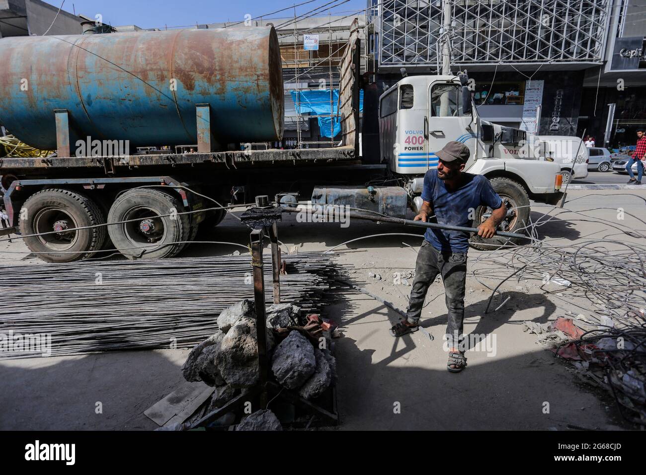 An Egyptian worker recycles metal rods from the rubble of destroyed ...