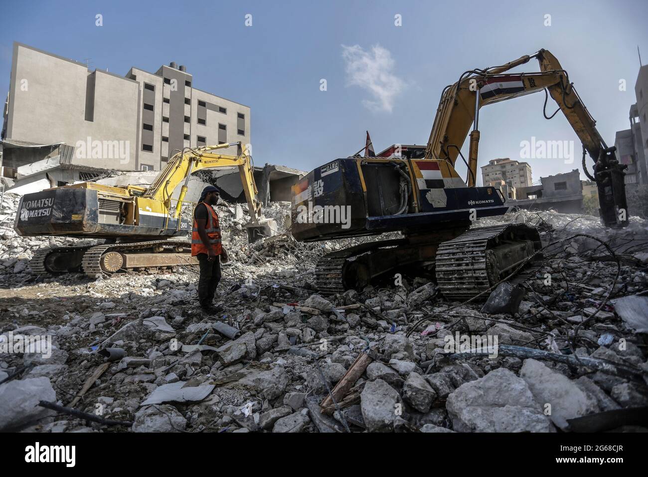 Egyptian workers with machines remove the rubble of the destroyed ...