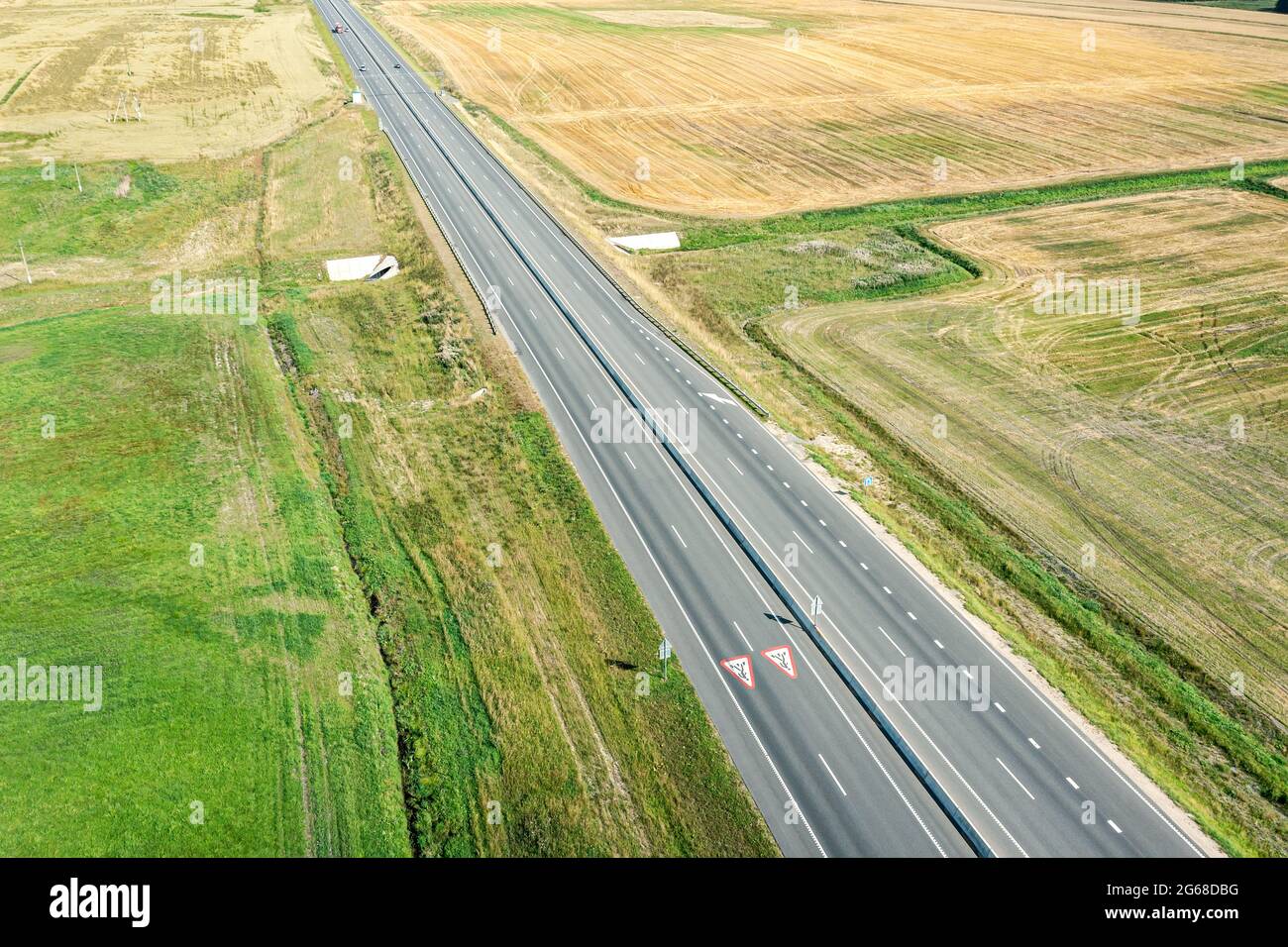 straight road pass through agricultural fields. summer landscape of ...