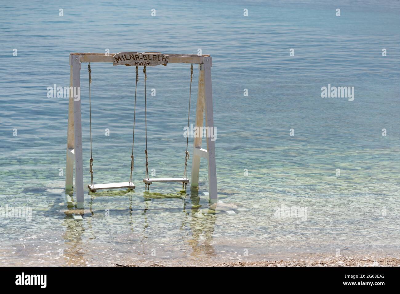 A swing placed in the water of the sea right on the shore Stock Photo ...