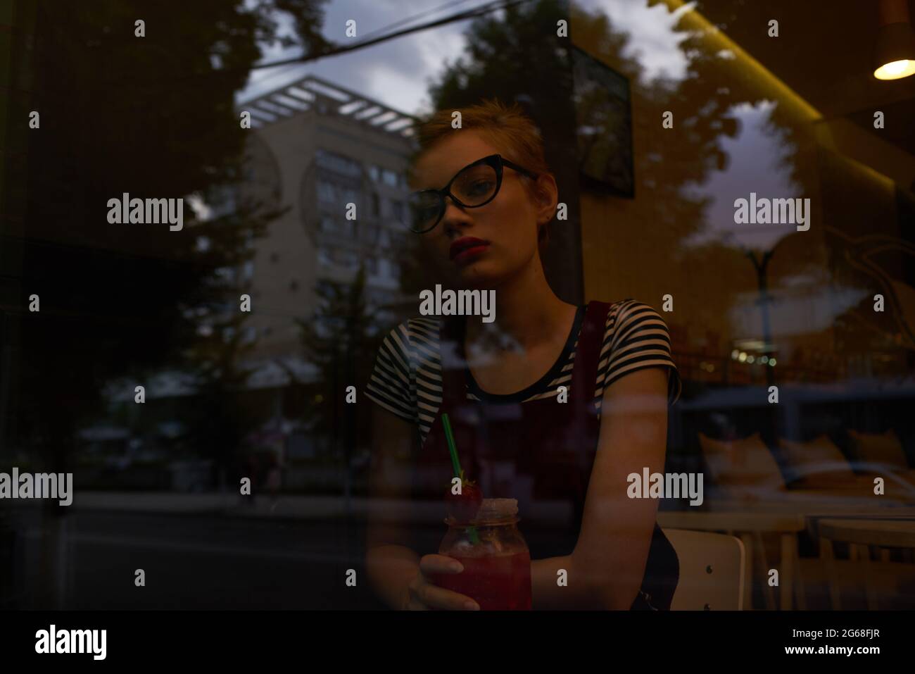 woman looking out the window at the street cafe cocktail drink ...