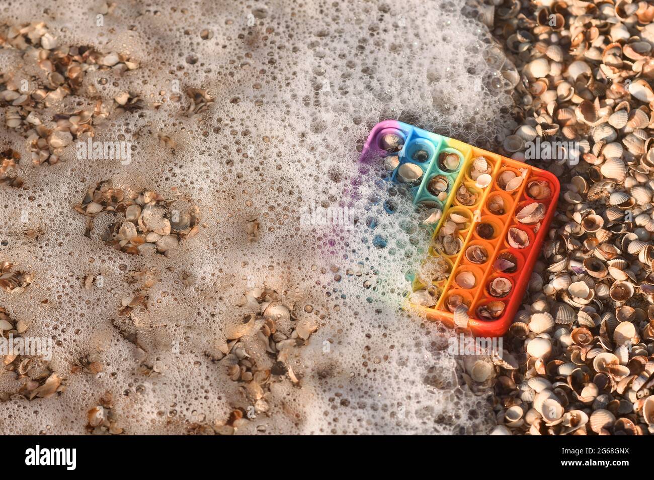 Pop it is a rubber toy on seashells in foamed seawater Stock Photo - Alamy