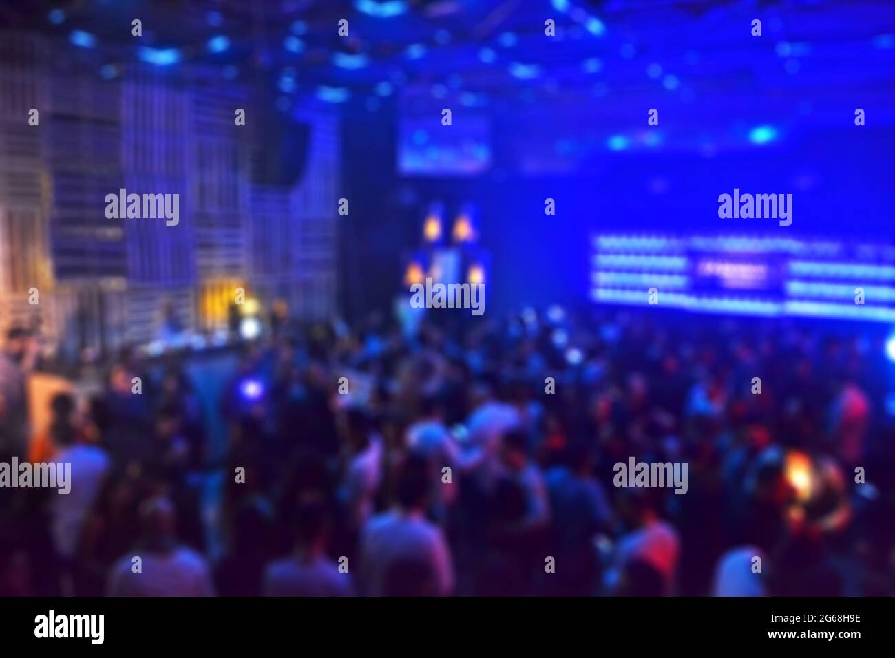 Blurred background of a crowded disco party with people drinking and ...