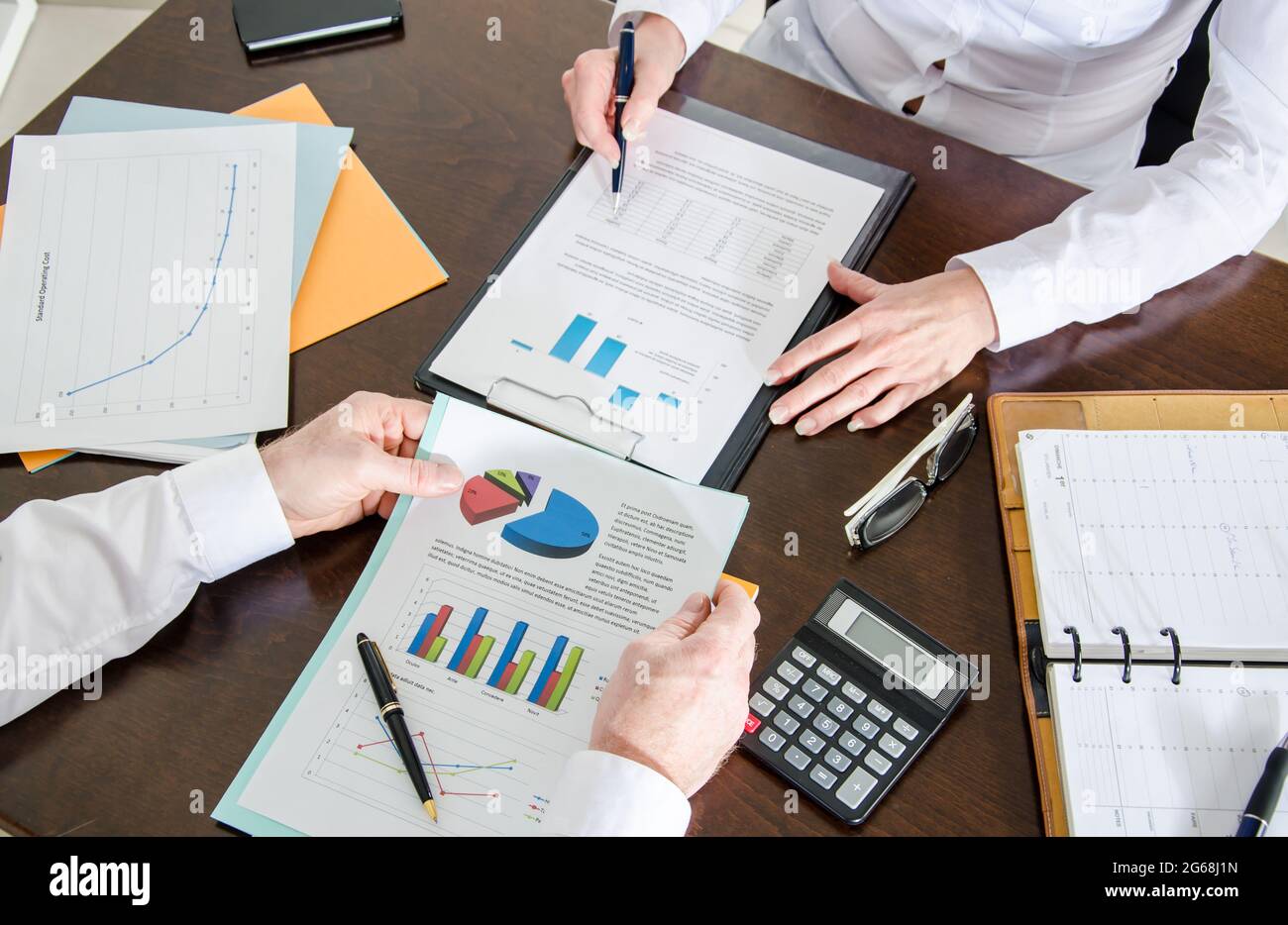 Two business people analyzing charts Stock Photo - Alamy