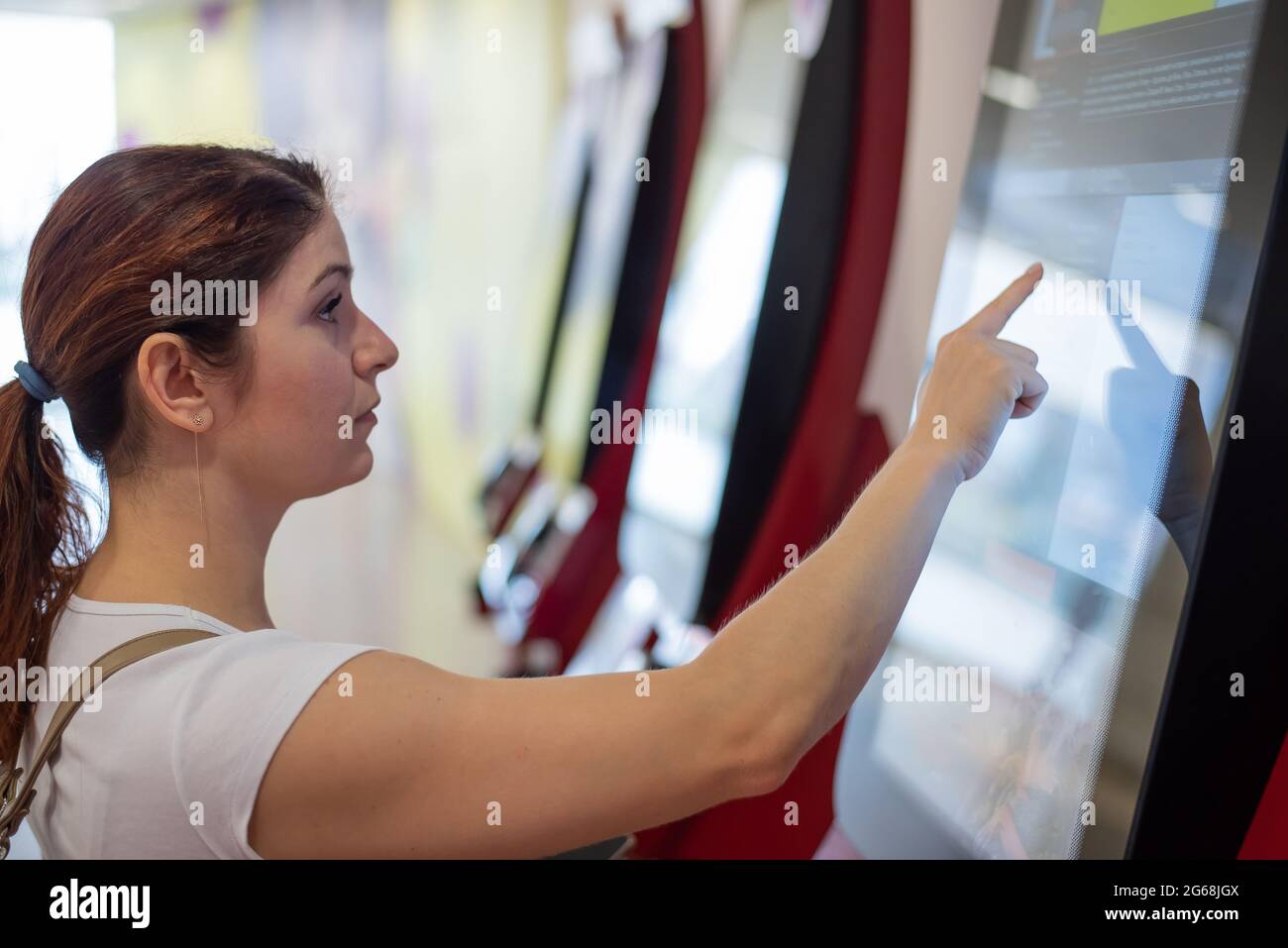Woman uses touch information desk in shopping mall Stock Photo - Alamy