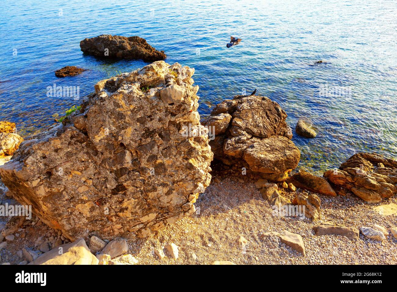 Coastal scenery with big rocks . Pebble beach and transparent water ...