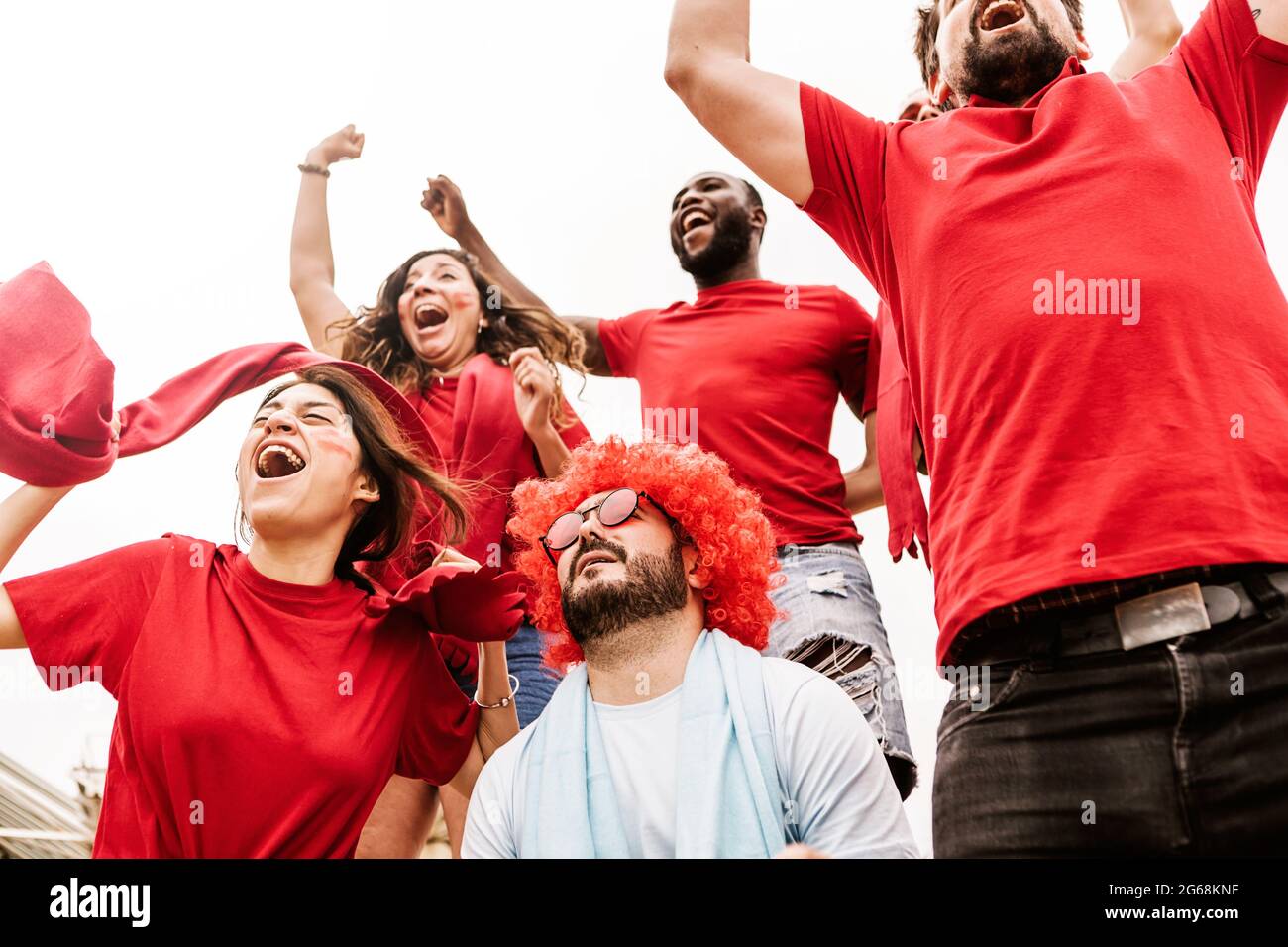 Football fans celebrating victory at stadium with disappointed rival ...