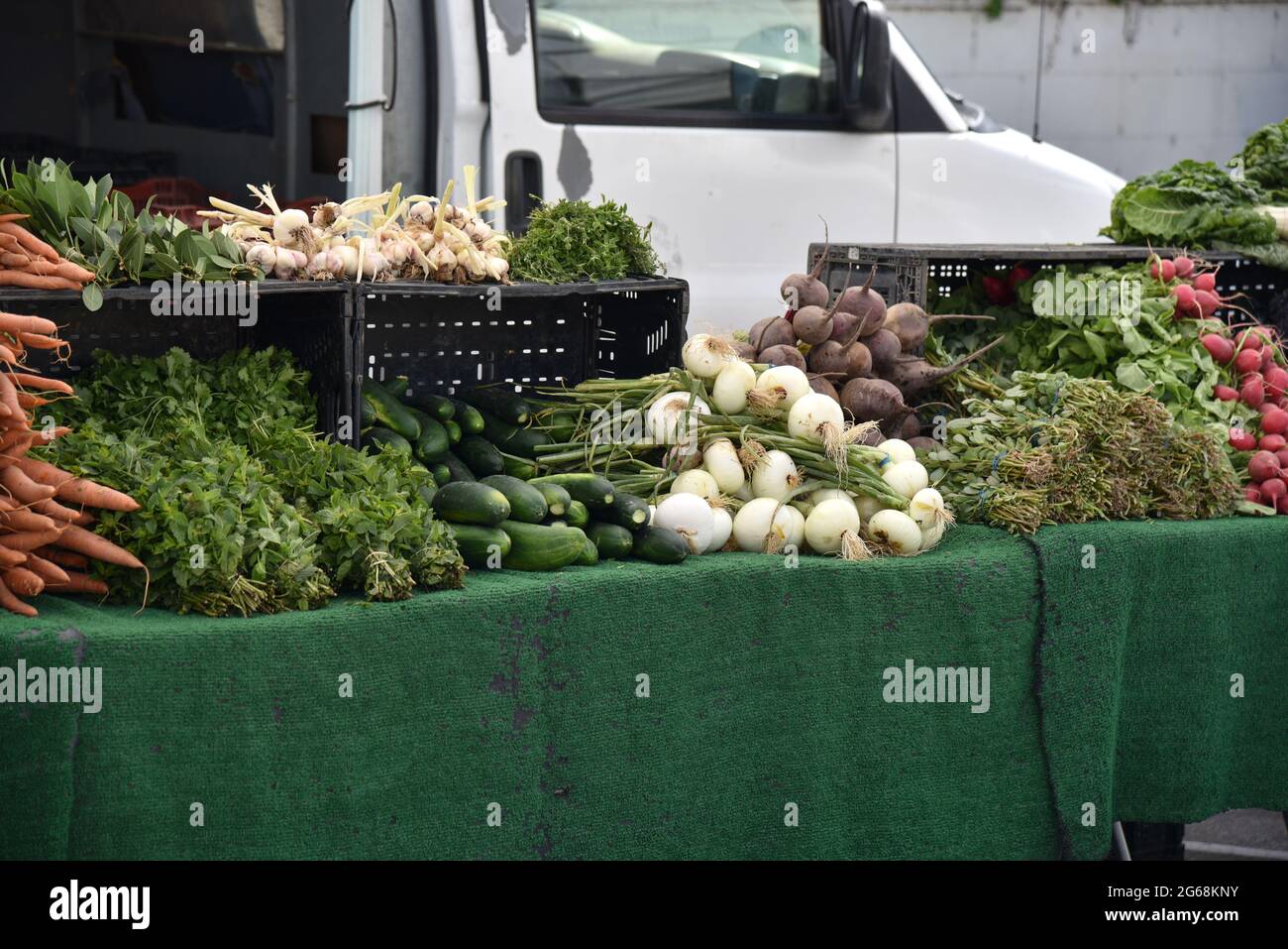 Fresh cucumbers, onions and other produce at a roadside produce stand ...