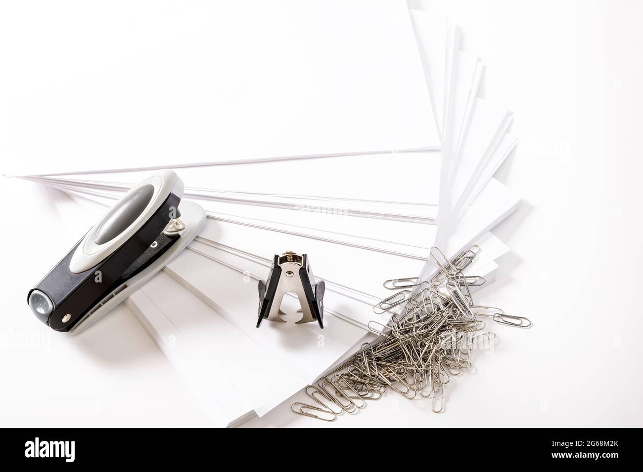Photograph of some fan-shaped sheets of paper, a stapler, a staple ...