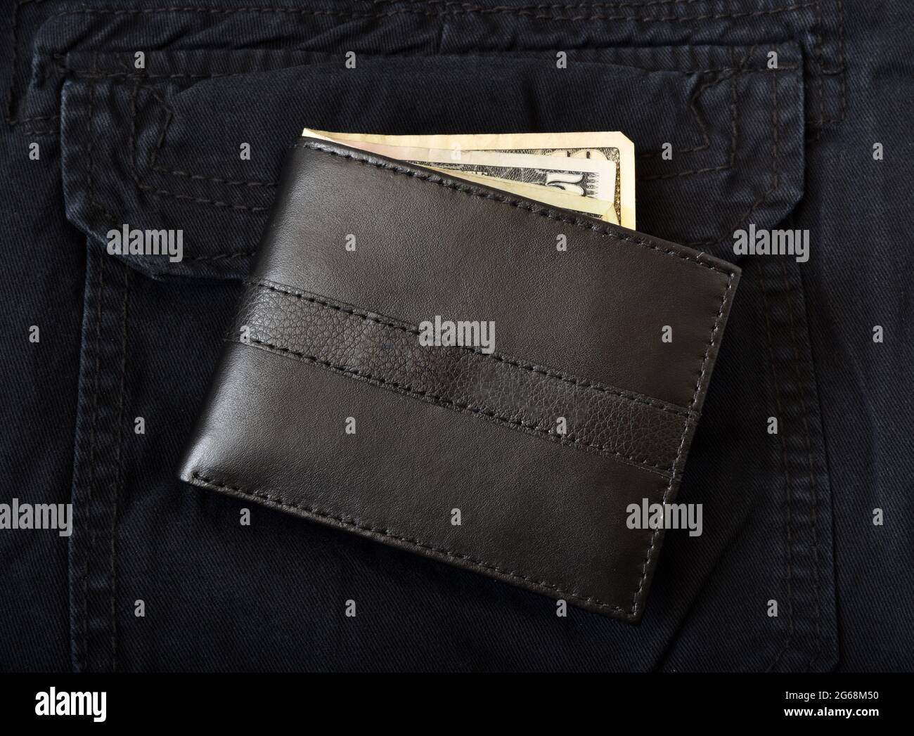 A wallet with cash laying on a pair of mens pants Stock Photo - Alamy