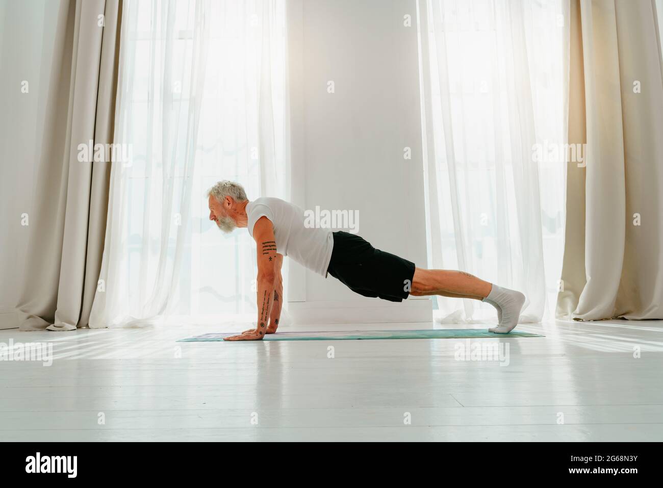 Sportive man does yoga exercise at home Stock Photo - Alamy