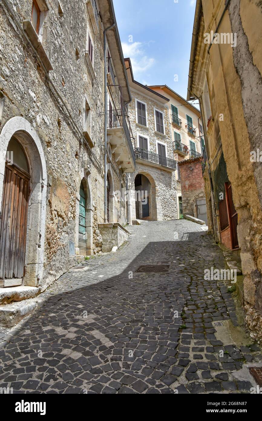 A narrow street between the old houses of Arce, a medieval village in ...
