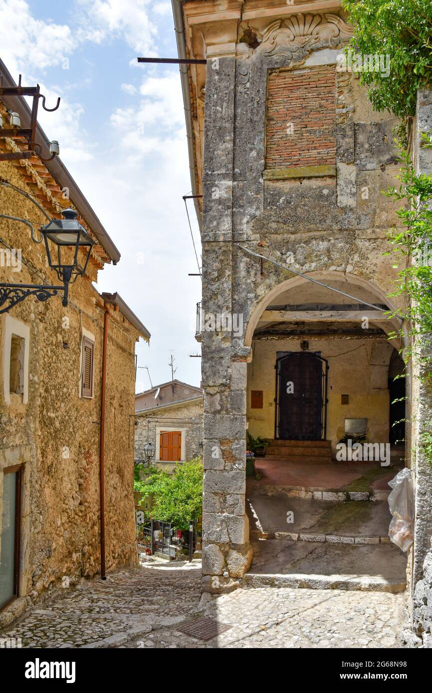 A narrow street between the old houses of Arce, a medieval village in ...