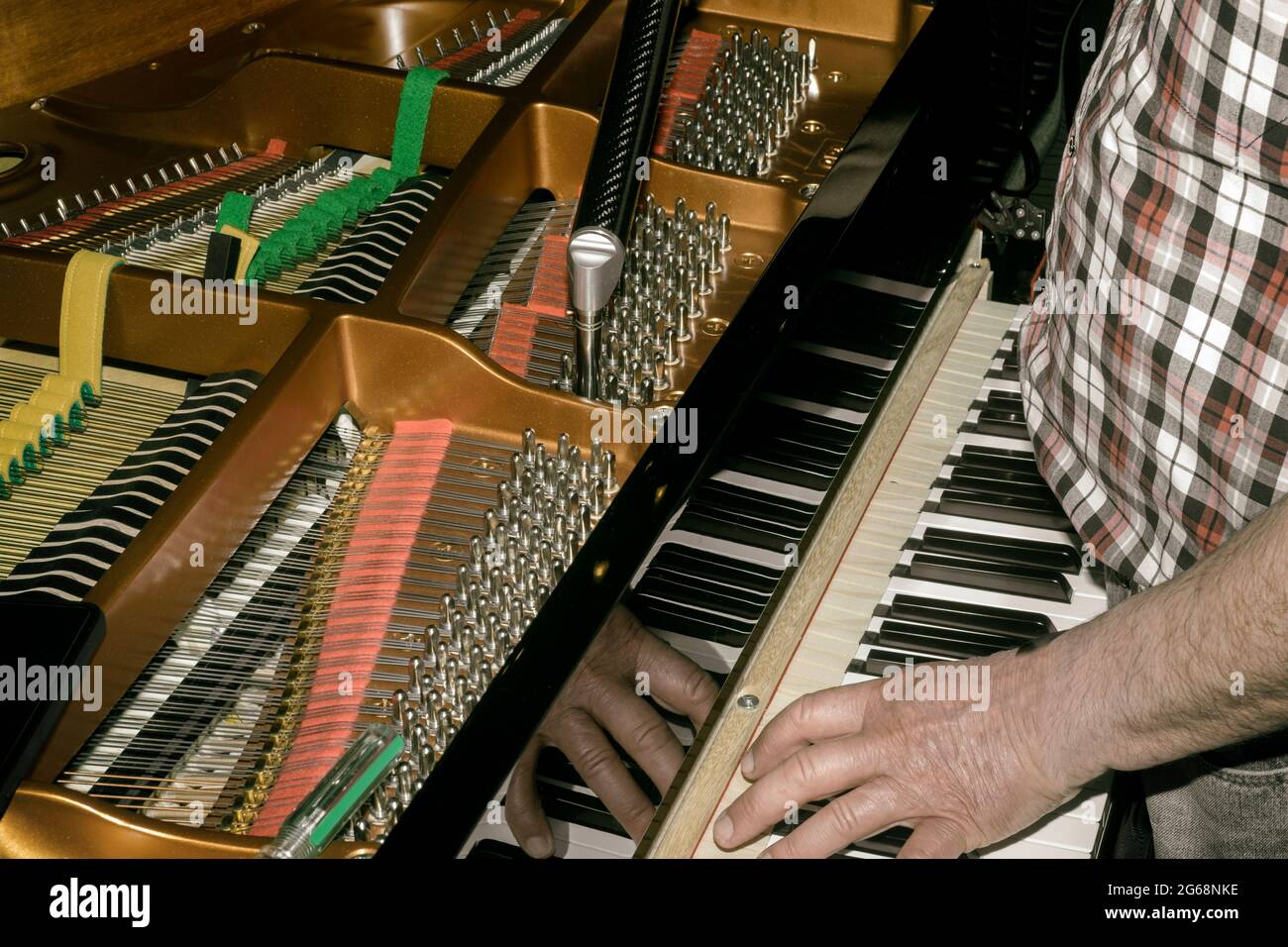 A tuner hand tapping note on a keyboard of piano while tuning Stock ...