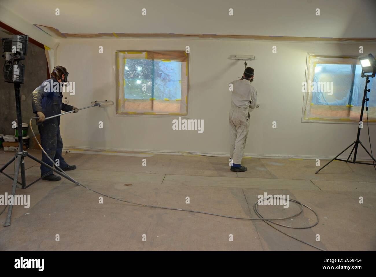 a tradesman using airless spray equipment to paint a top coat on the ...