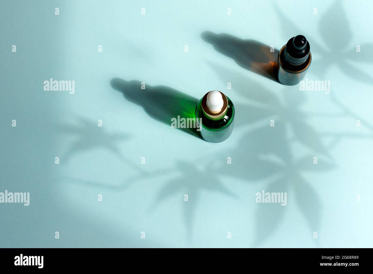 Face serum in bottle dropper with CBD oil on Hemp leaves shadows ...